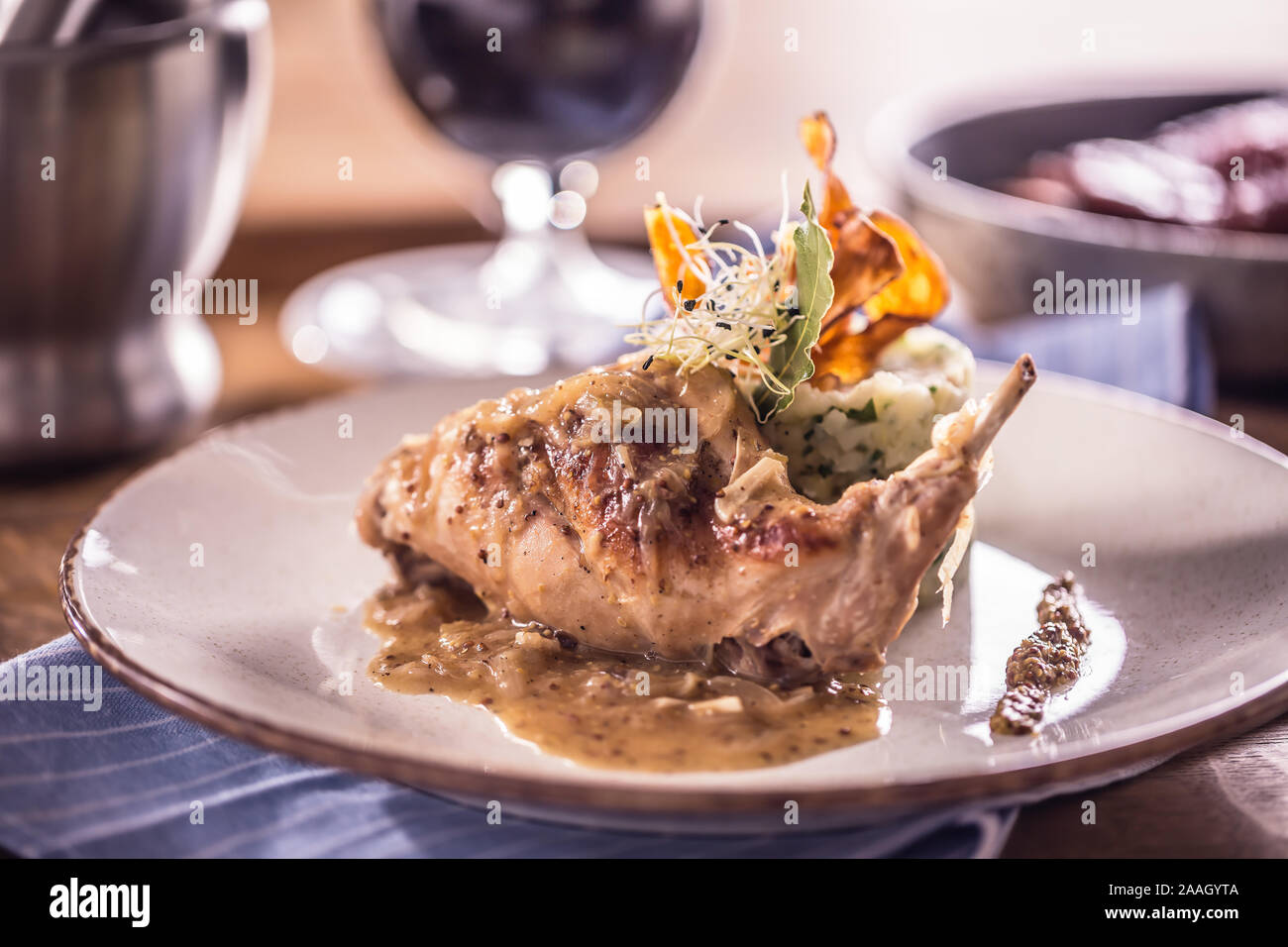 Rabbit leg with mashes potatoes and decoration on plate in restaurant ...