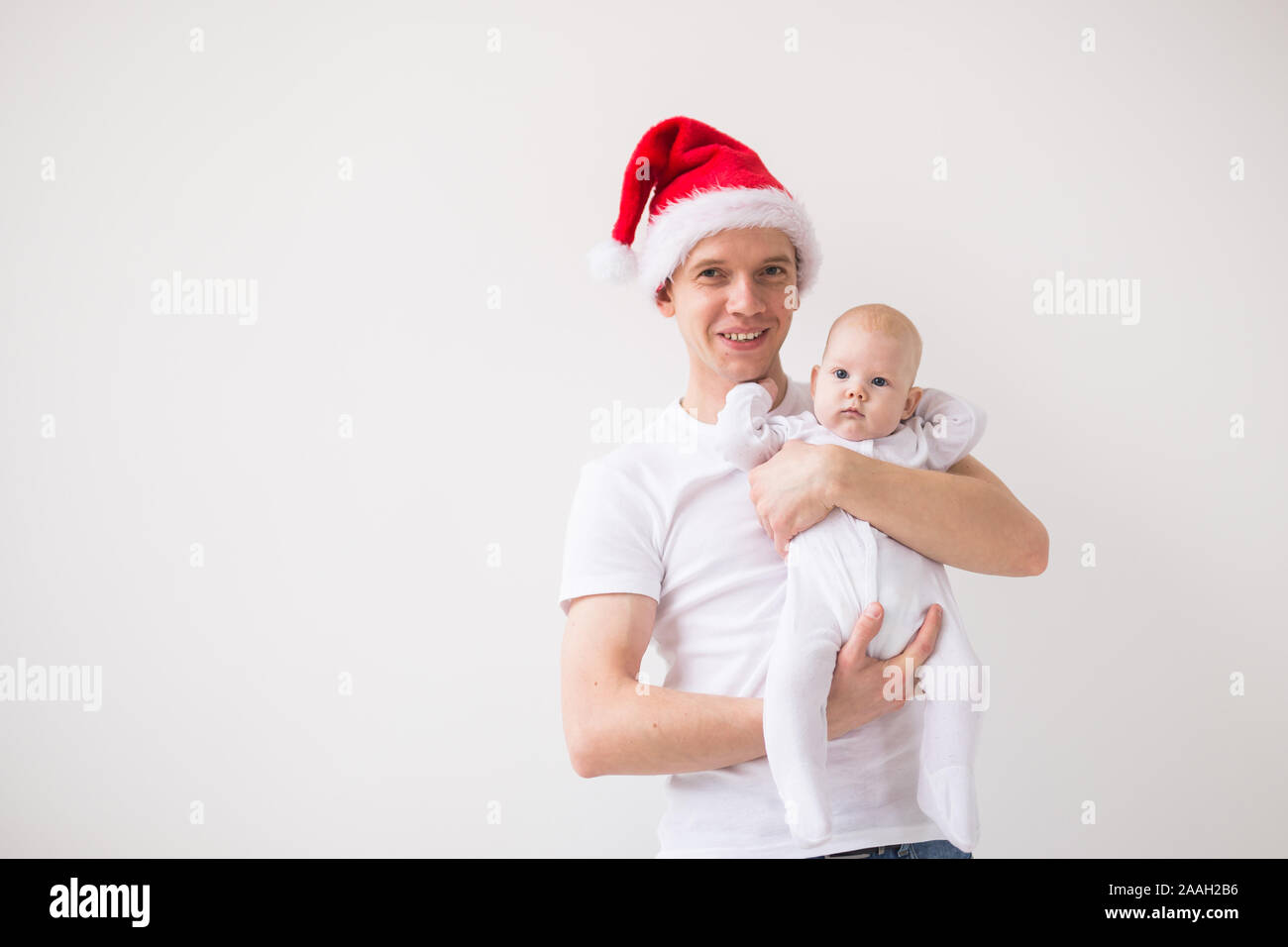 My first Christmas. Dad in santa hat holding his baby girl daughter on ...