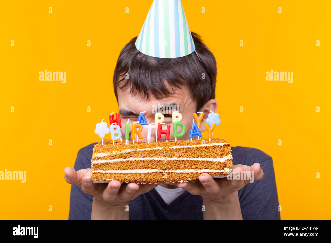 Crazy cheerful young man in glasses and paper congratulatory hats ...