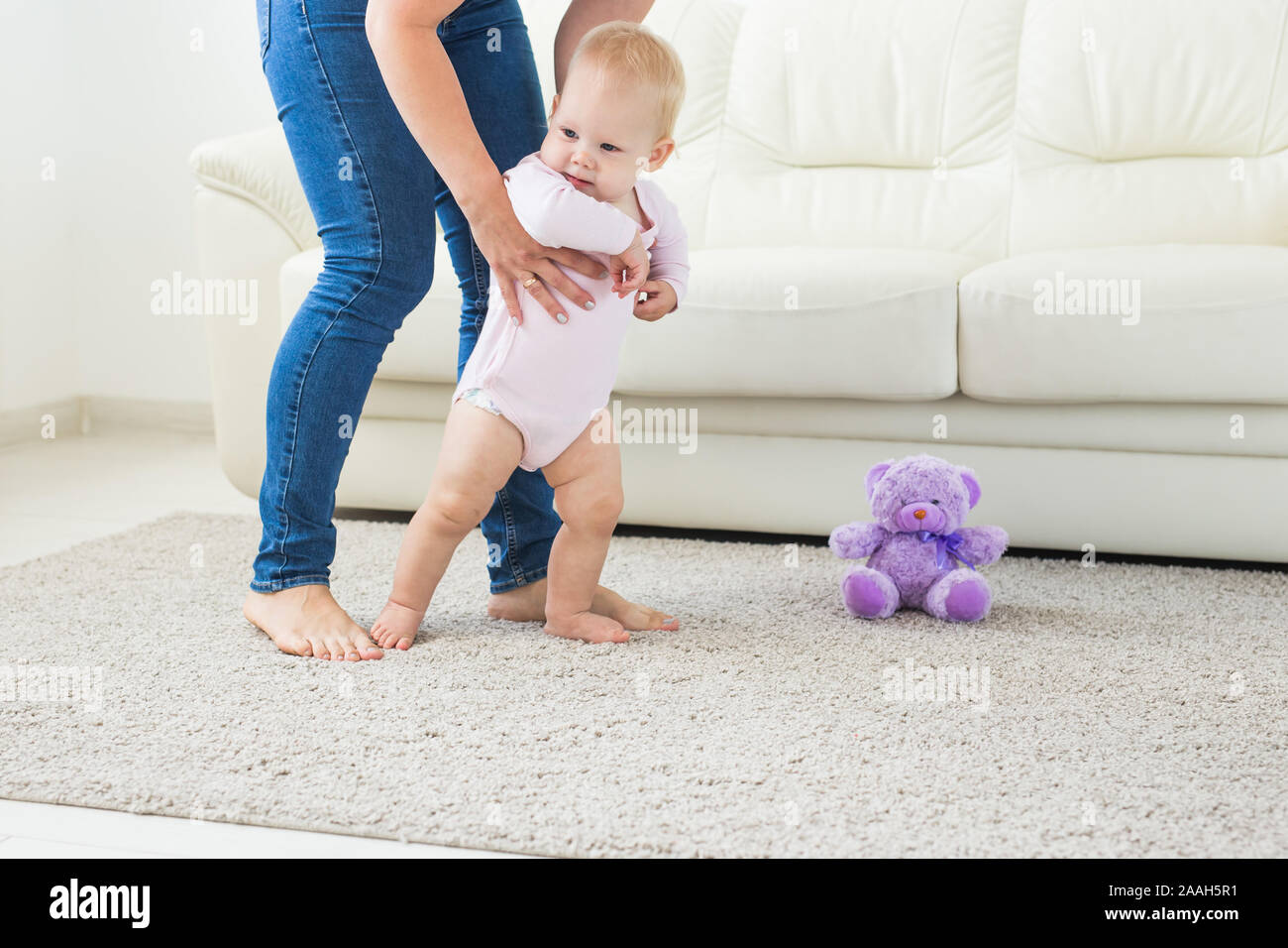 Baby taking first steps with mother's help at home Stock Photo - Alamy