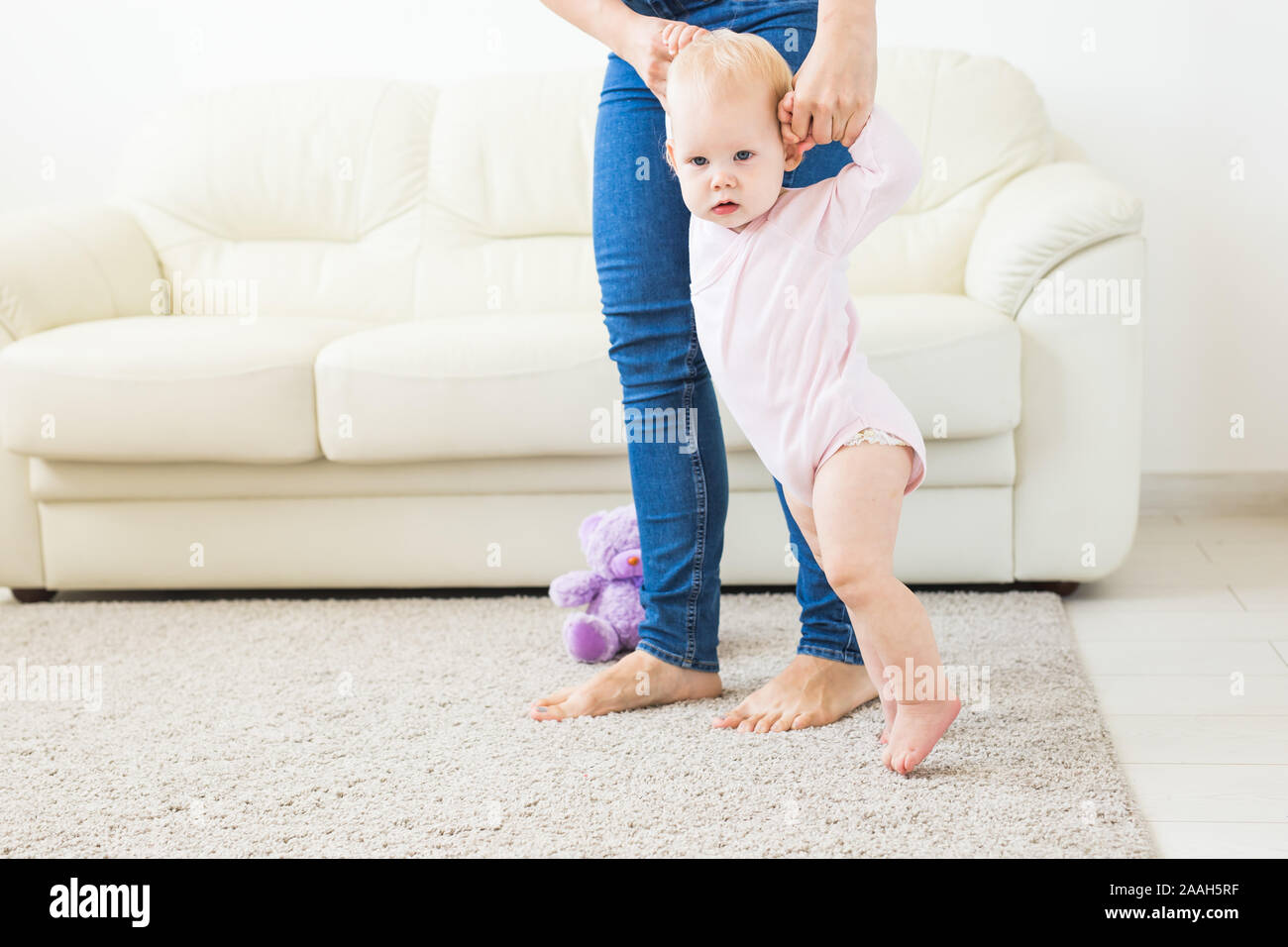 First steps. Little baby girl learning to walk. Studio shoot on white ...