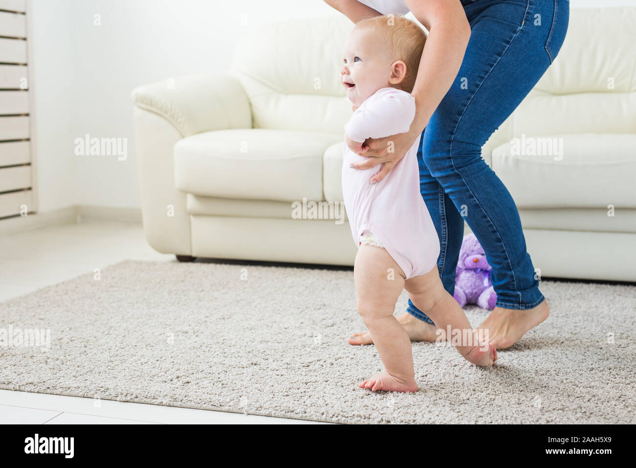 First steps. Little baby girl learning to walk. Studio shoot on white ...