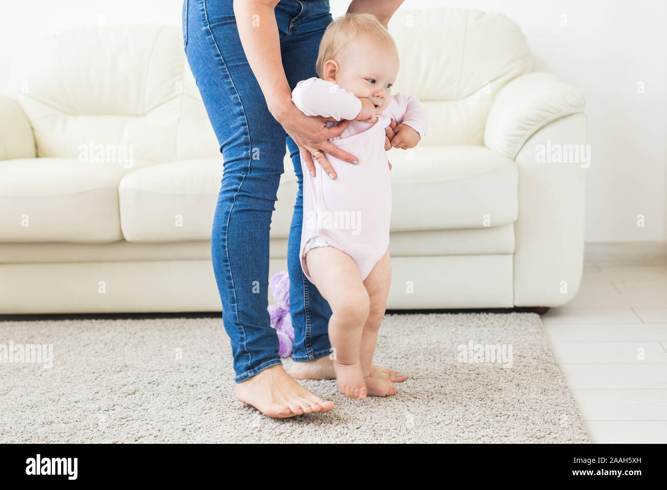 little girl first steps with the help of mom Stock Photo - Alamy