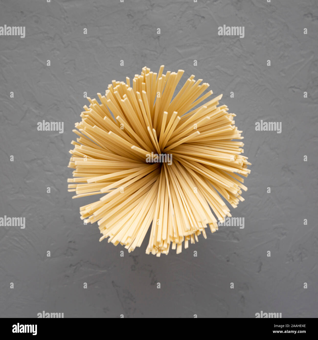 Uncooked dry white Ramen noodles over gray surface, view from above ...