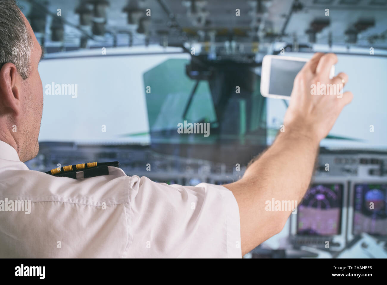 Airline pilot wearing uniform with epauletes taking pictures with smart ...