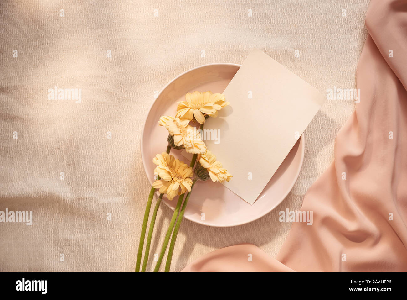 Flowers on plate with card and fabric on the light background Stock ...