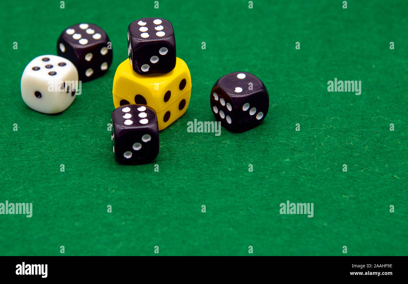 Different in color dice on a green background Stock Photo - Alamy