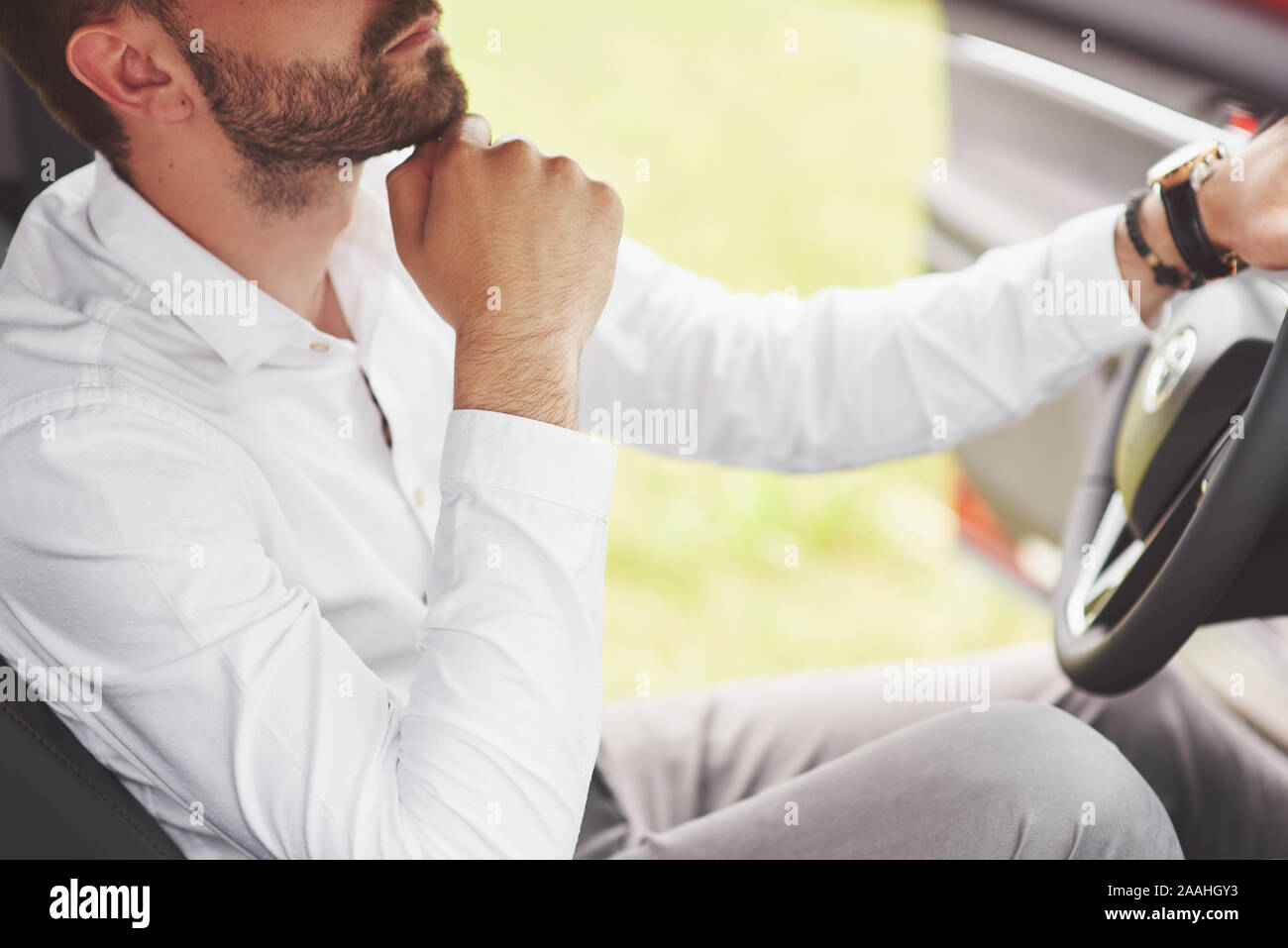 Beautiful young man in full suit while driving a car Stock Photo - Alamy