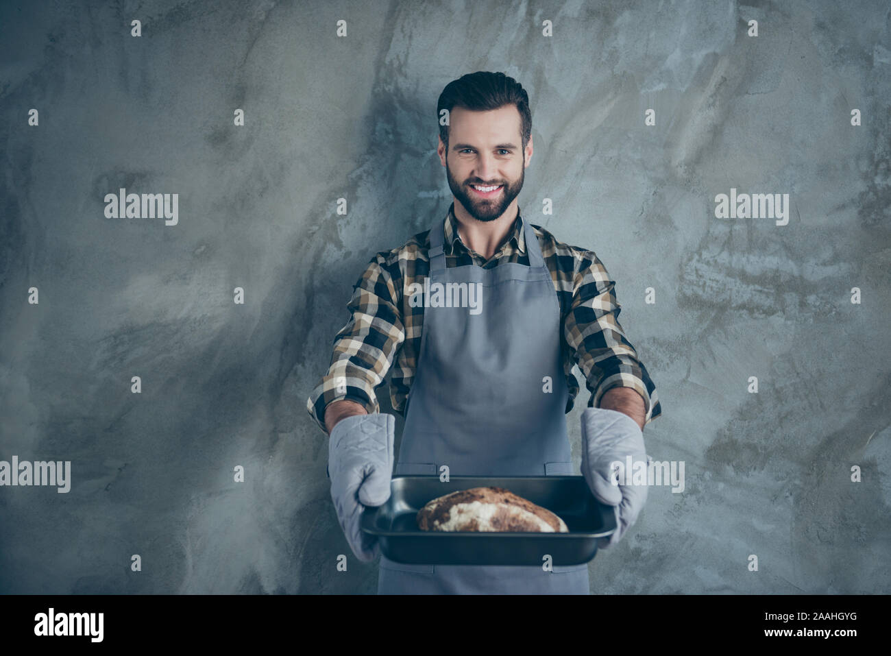 Photo of cheerful positive cook chef having cooked his branded bread ...