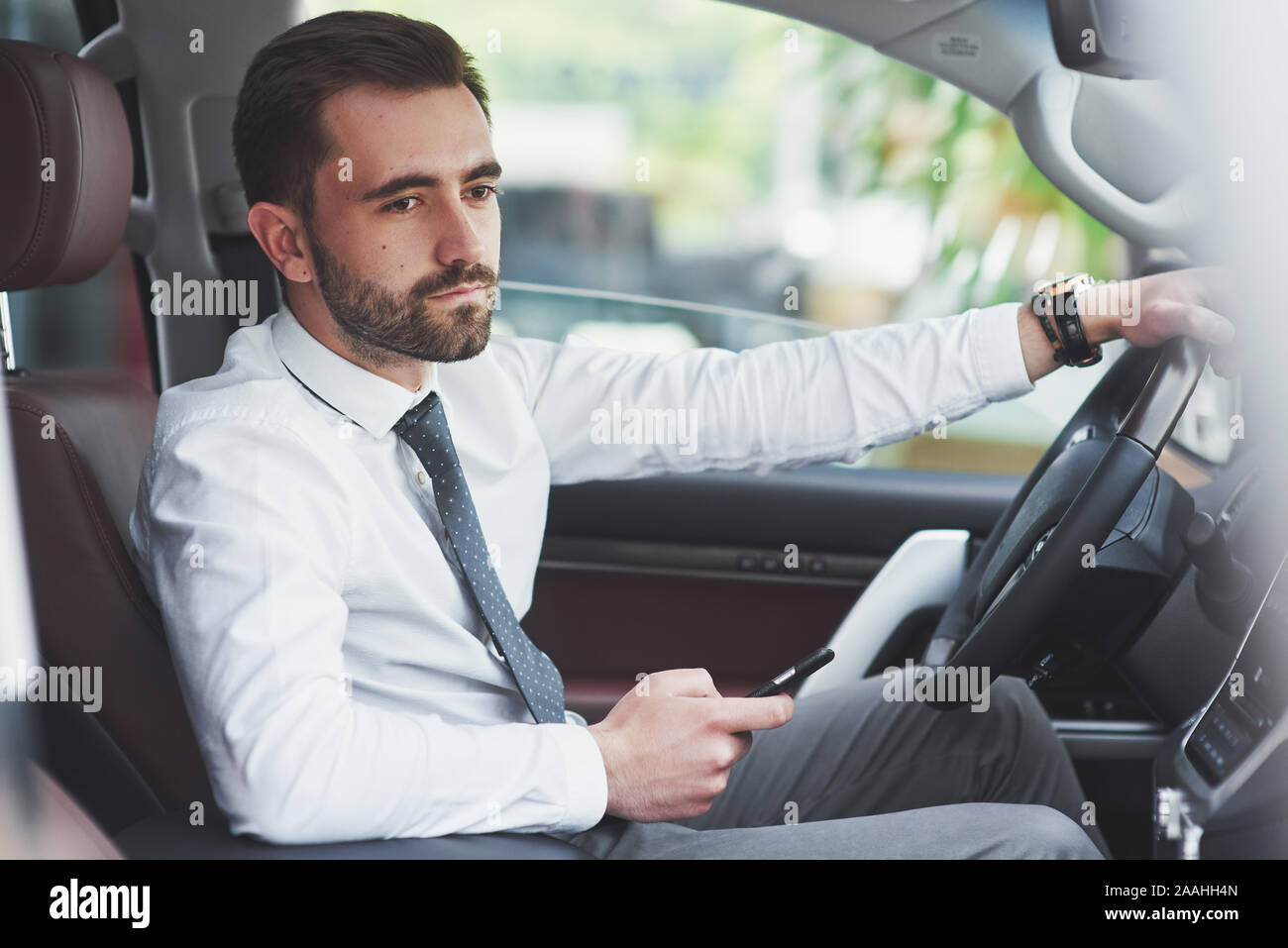 Beautiful young man in full suit while driving a car Stock Photo - Alamy