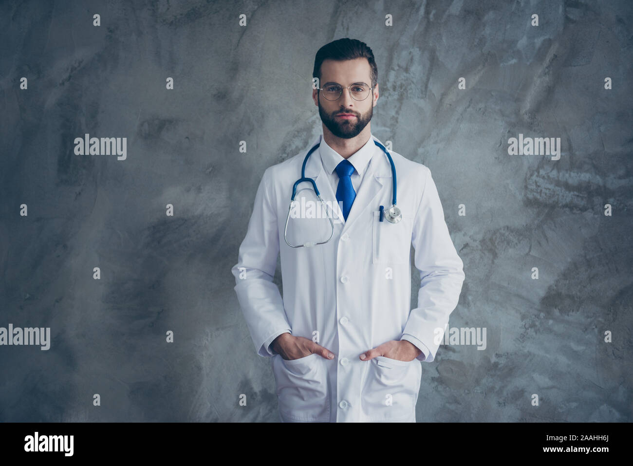 Portrait of serious talented doctor put his hands in pockets of white ...