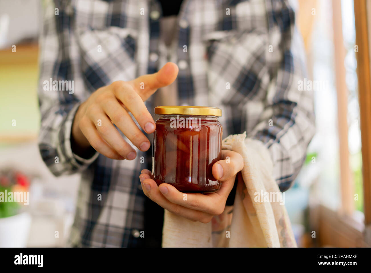 person hand holding a homemade jar of jam with fruits, glass pots Stock ...