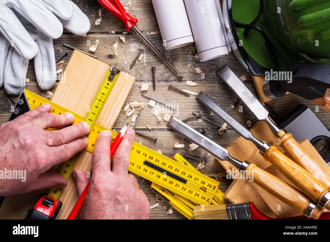 Top view. Carpenter with pencil, carpenter's square and meter marks the ...