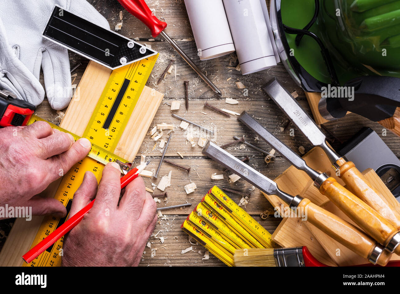 Top view. Carpenter with pencil, carpenter's square and meter marks the ...