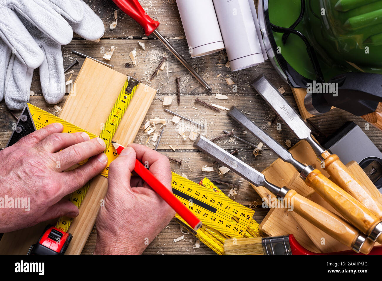 Top view. Carpenter with pencil, carpenter's square and meter marks the ...