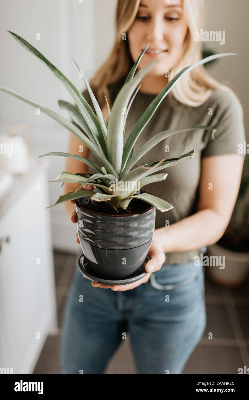 Woman carrying pot plant hi-res stock photography and images - Alamy