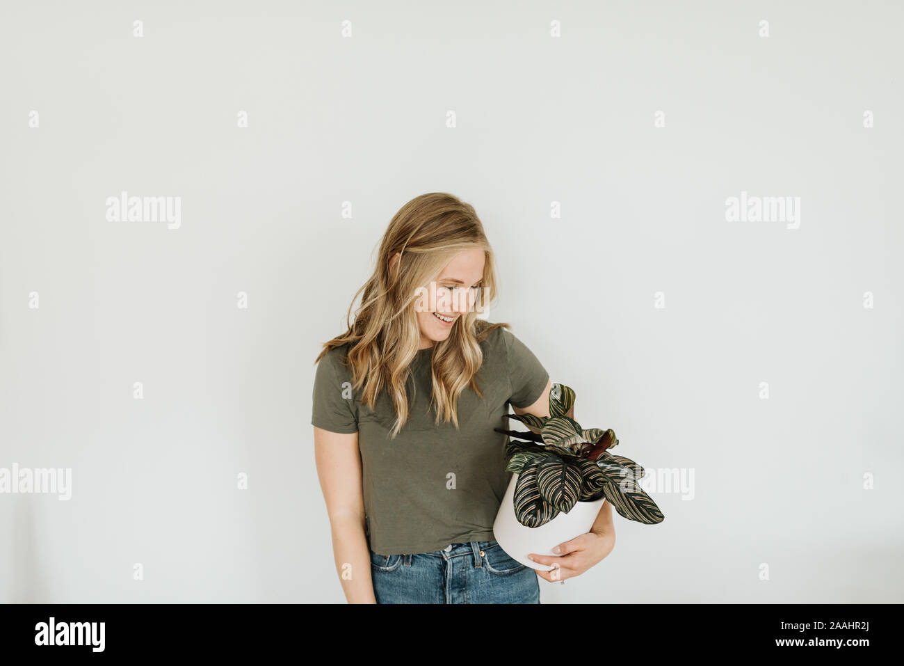 Woman carrying pot plant hi-res stock photography and images - Alamy
