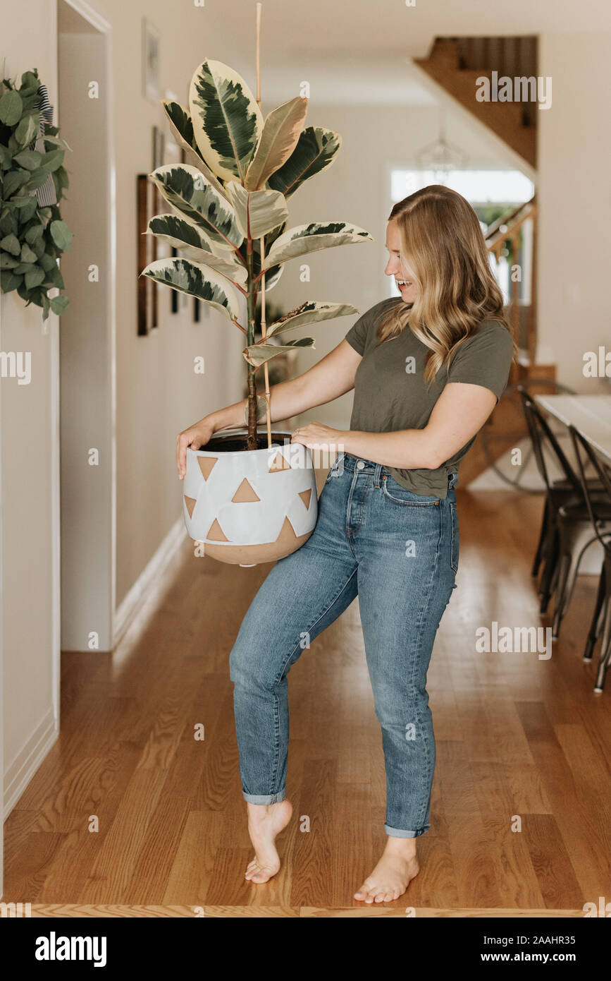 Woman carrying large plant hi-res stock photography and images - Alamy
