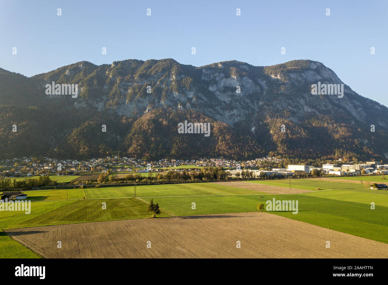 Aerial view of green meadows with villages and forest in austrian Alps ...