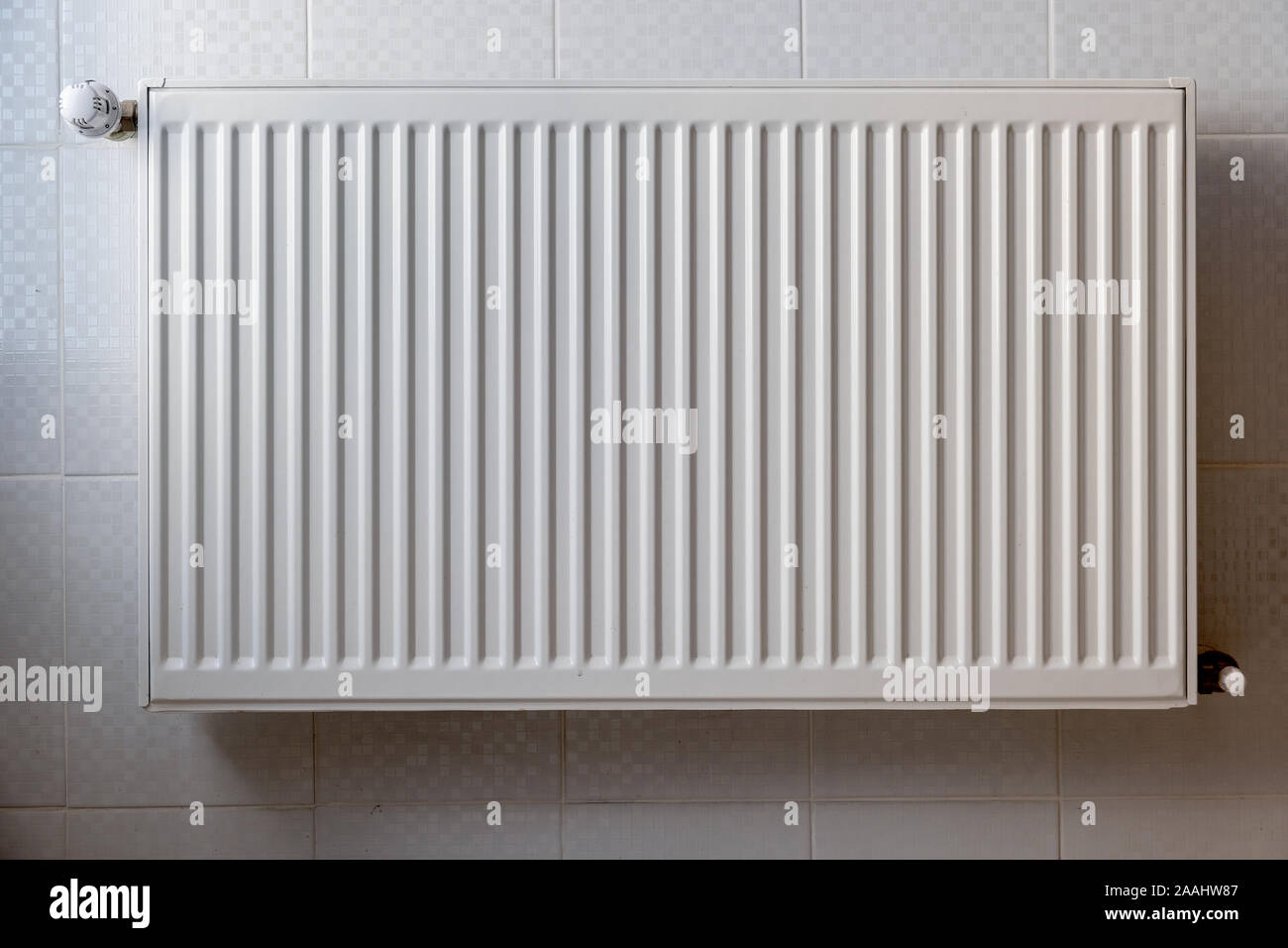 White metal heating radiator mounted on a wall in room interior Stock ...