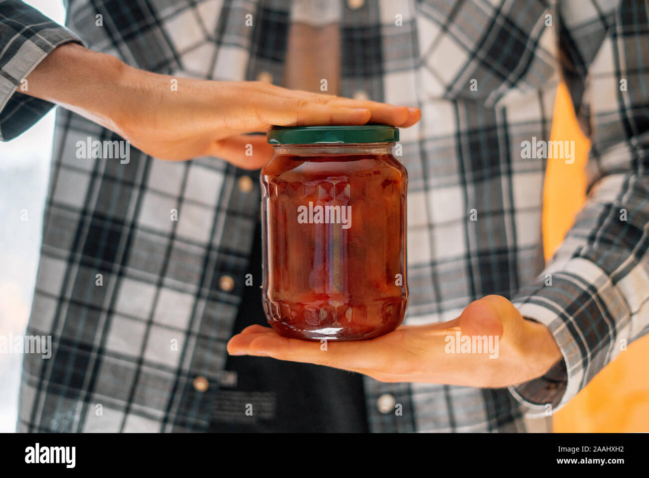 person hand holding a homemade jar of jam with fruits, glass pots Stock ...