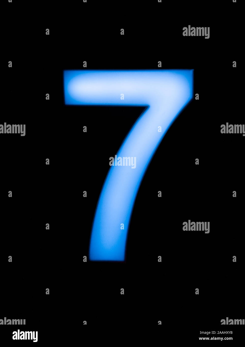 Front view of blue illuminated number 7 symbol marquee sign on black ...