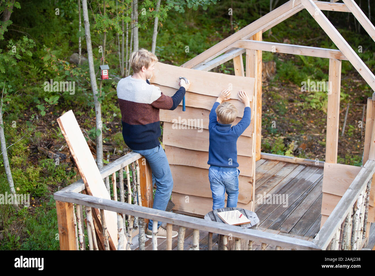 Father and son building treehouse together in garden Stock Photo - Alamy