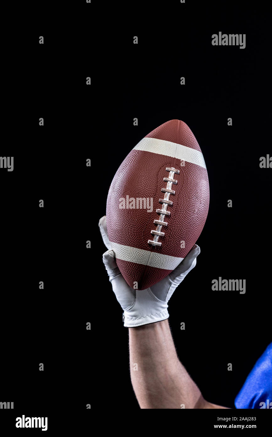 Hand of a player holding American football Stock Photo - Alamy