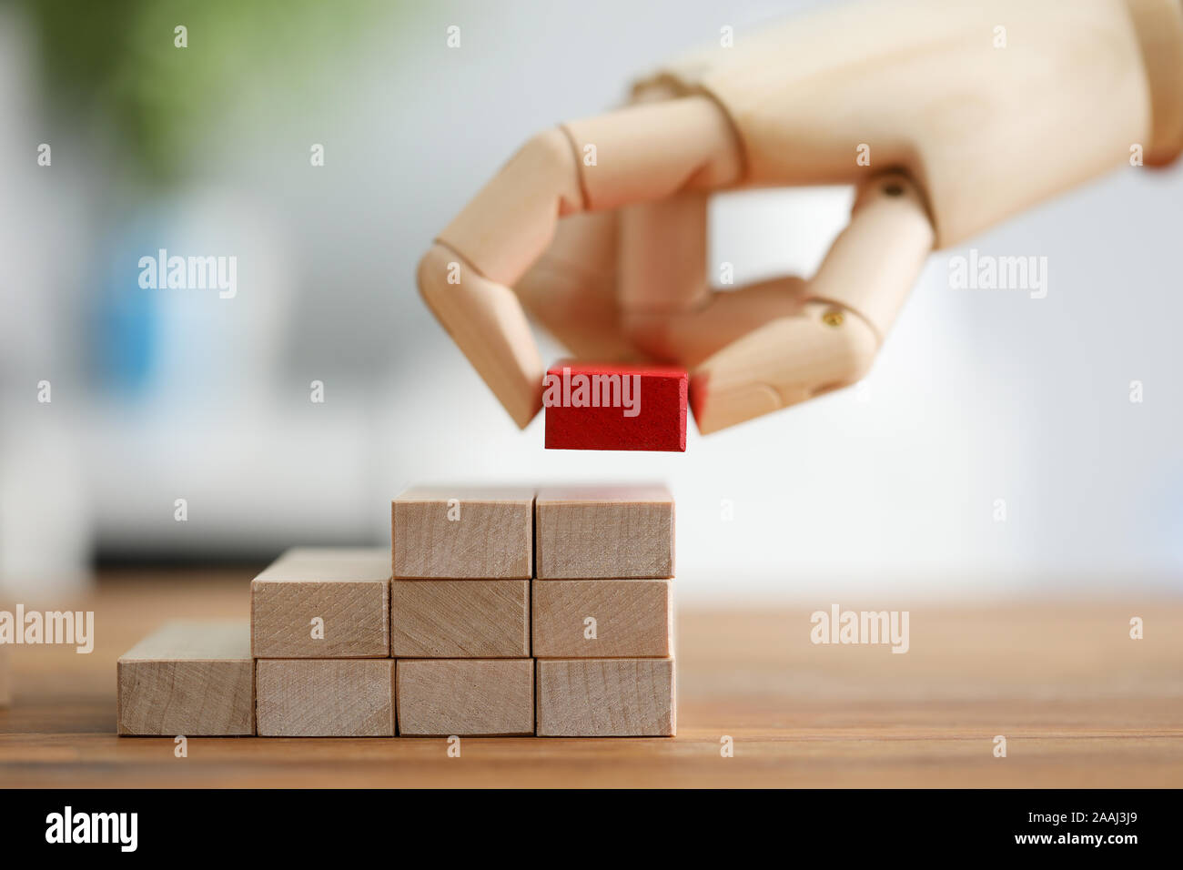 Wooden businessman hand hold brown block against Stock Photo - Alamy