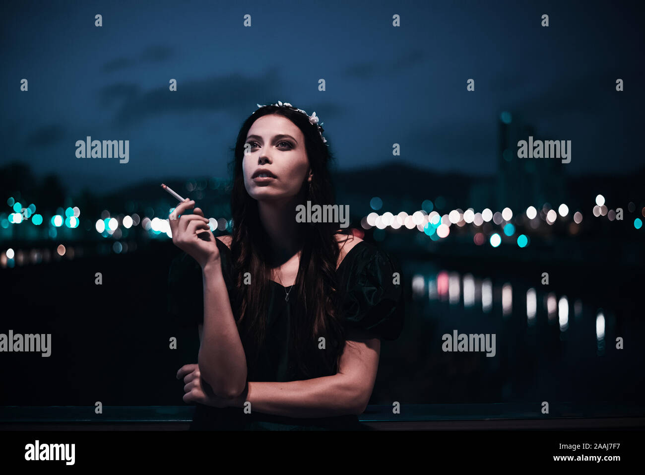 beautiful young woman in elegant vintage clothing smoking n an urban ...