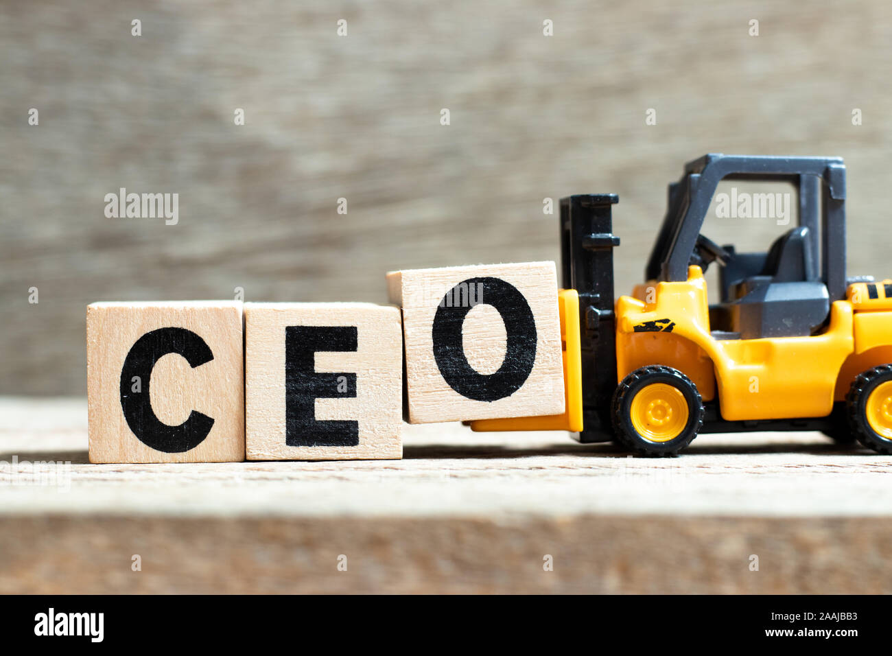 Toy forklift hold letter block o to complete word CEO (abbreviation of ...