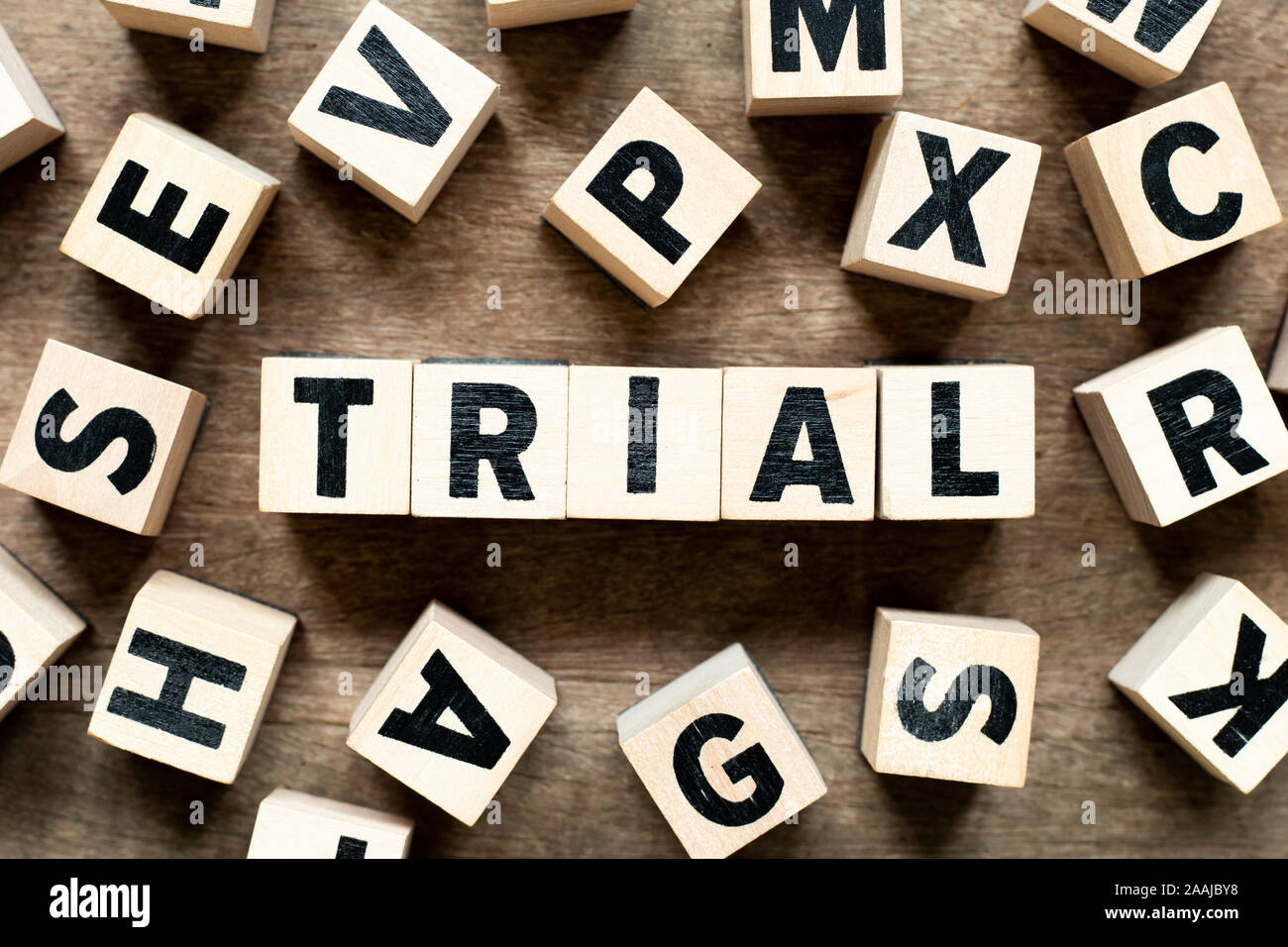 Letter block with word trial on wood background with another alphabet ...