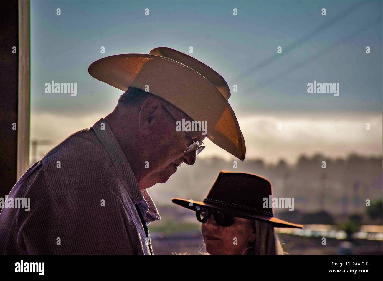 Senior couple in cowboy hats at family gathering in the ranch house ...