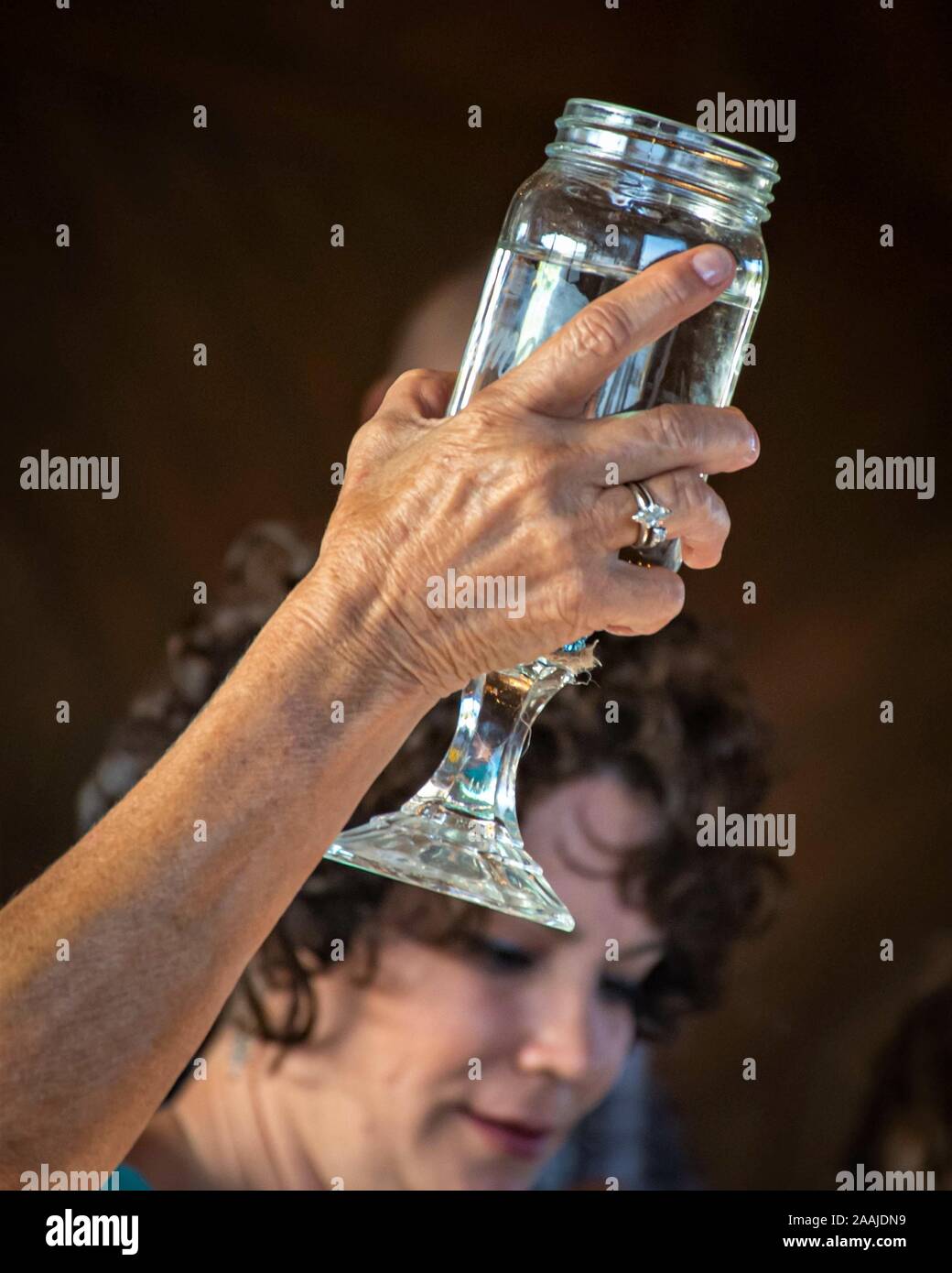 Hand during toast with homemade handmake glass at family gathering ...