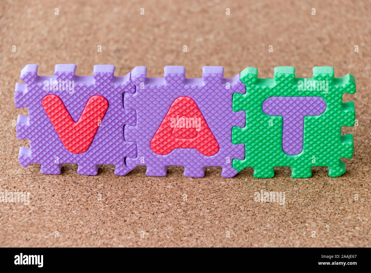 Colorful toy foam alphabet in word VAT on cork board background Stock ...