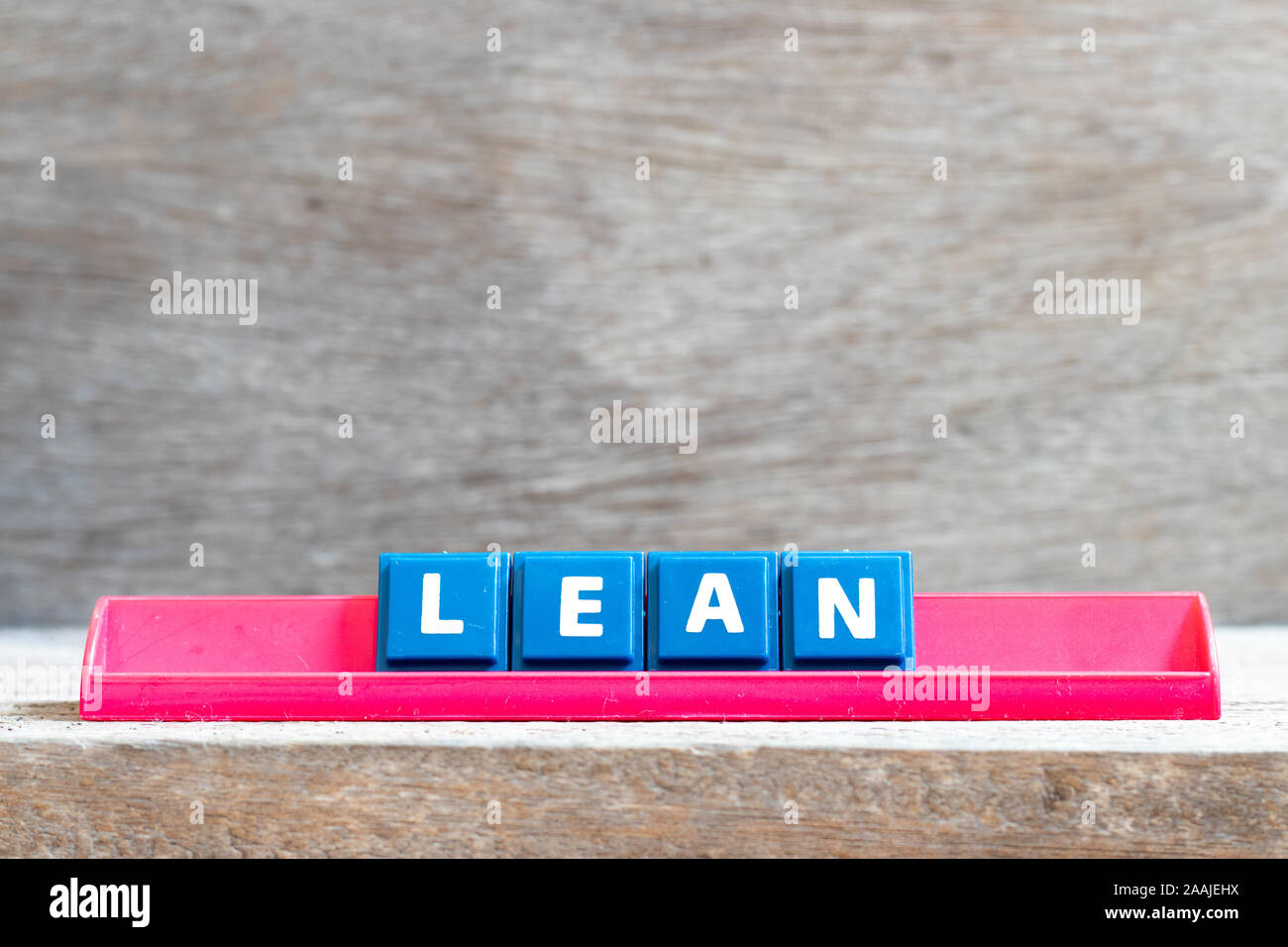 Tile letter on red rack in word lean on wood background Stock Photo - Alamy