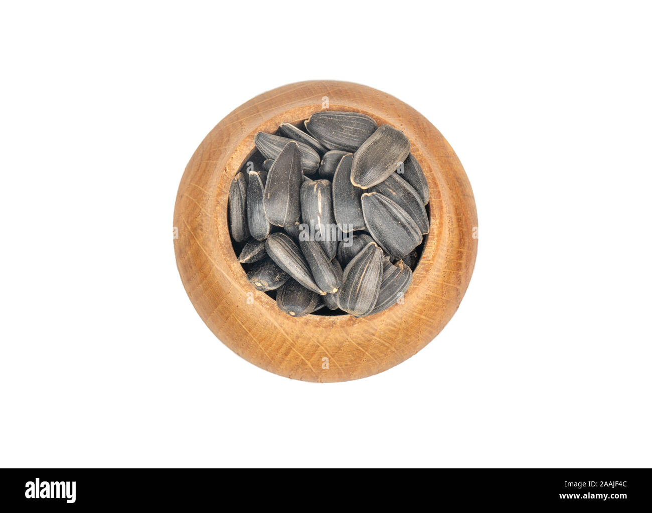 Sunflower seeds in a shell and a wooden container on a white background ...
