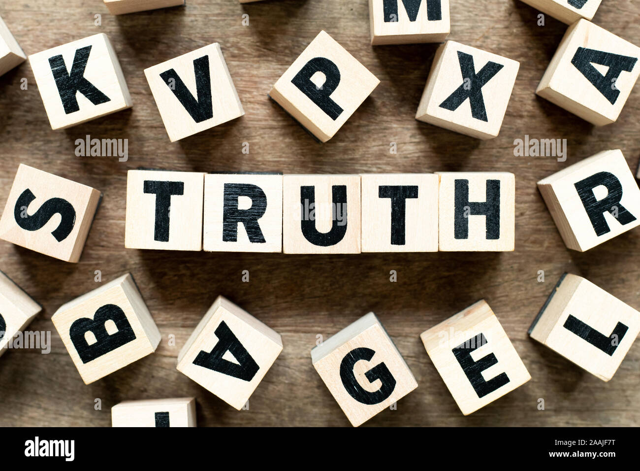 Letter block with word truth on wood background with another alphabet ...