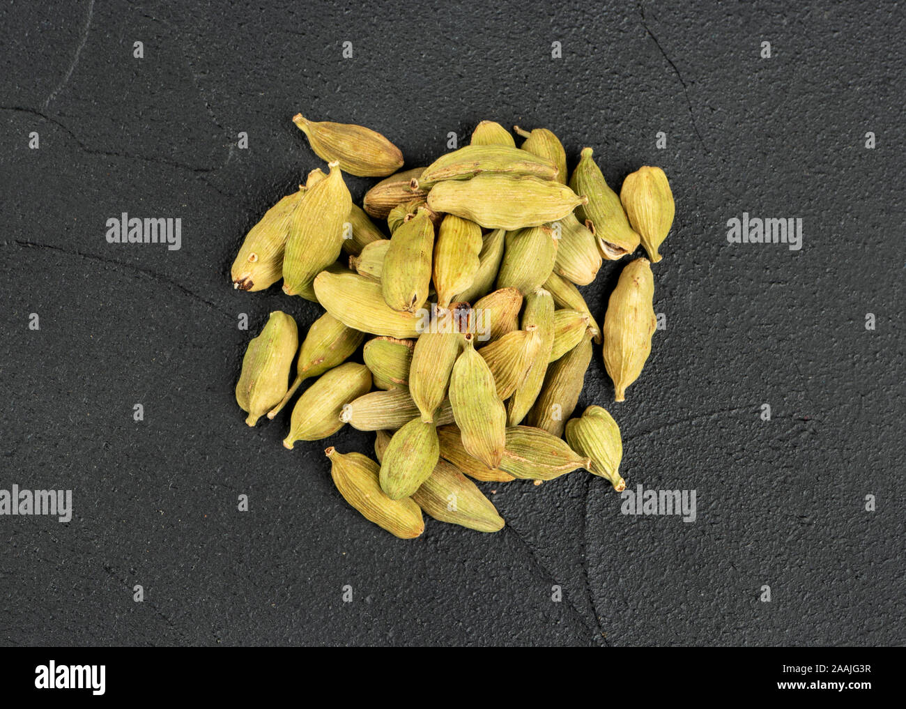 Pile of dry cardamom on dark concrete background, top view Stock Photo ...