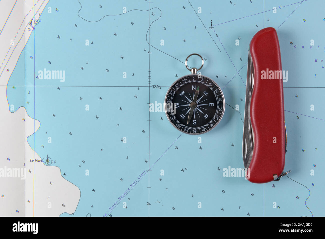 Magnetic compass and folding knife on a nautical navigational map Stock ...