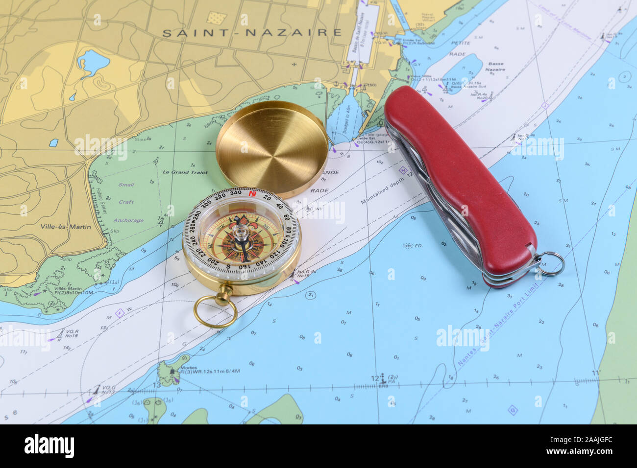 Magnetic compass and folding knife on a nautical navigational map Stock ...