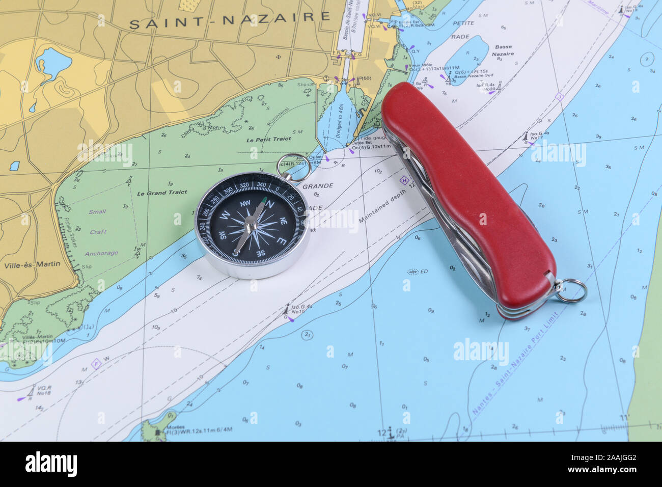 Magnetic compass and folding knife on a nautical navigational map Stock ...
