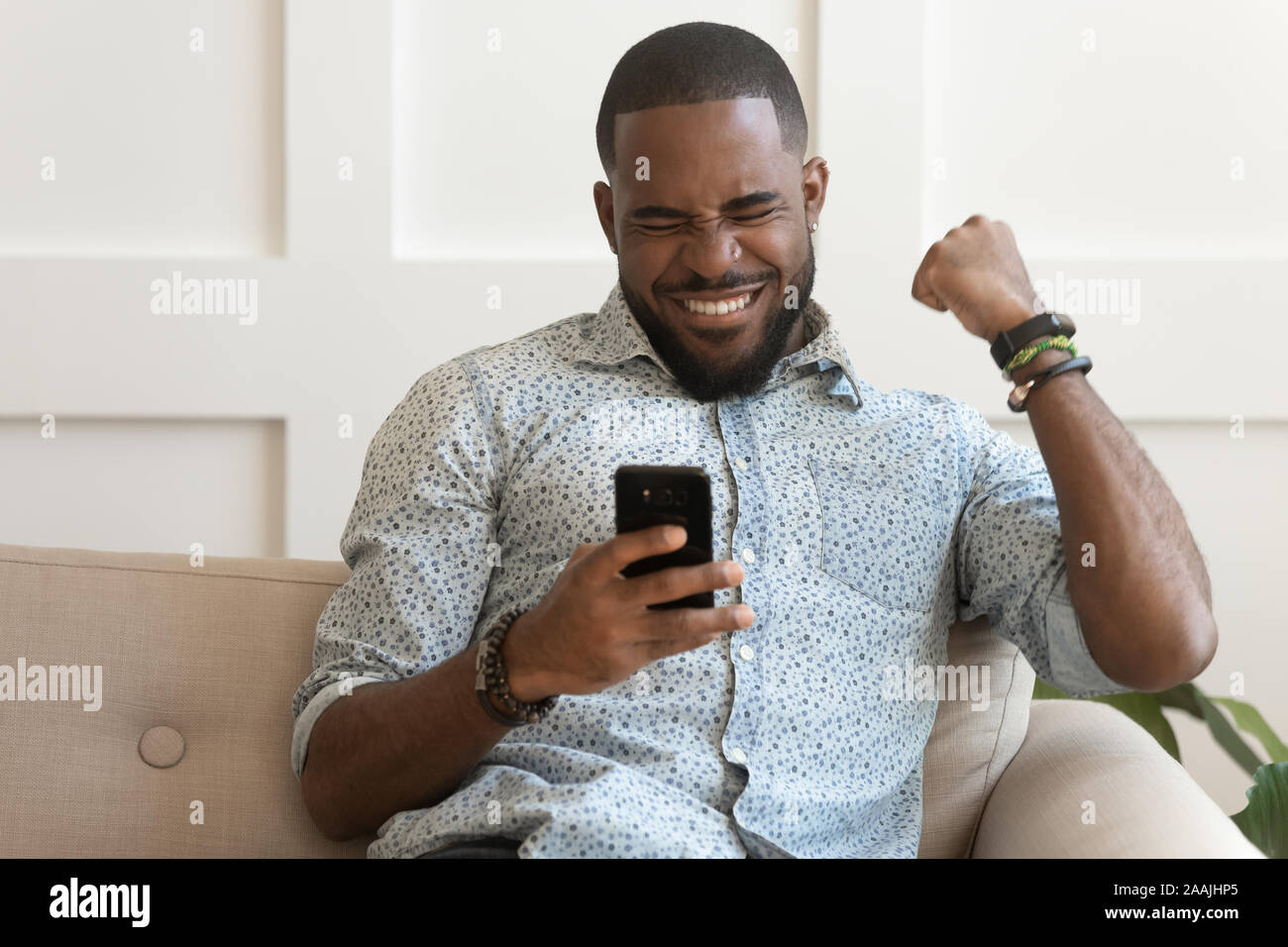 African man celebrating using smartphone hi-res stock photography and ...
