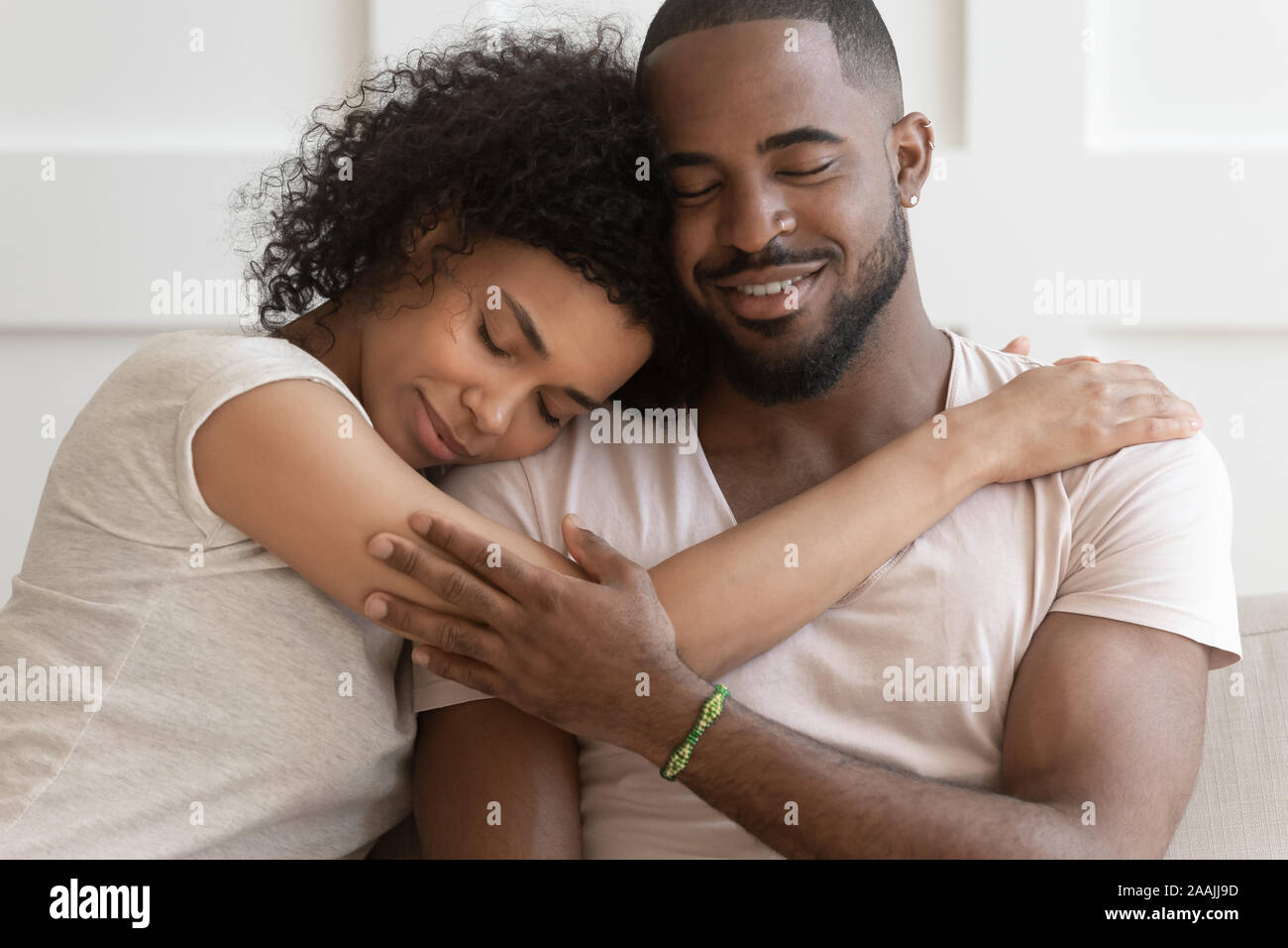 Happy African American couple cuddle hugging at home Stock Photo - Alamy