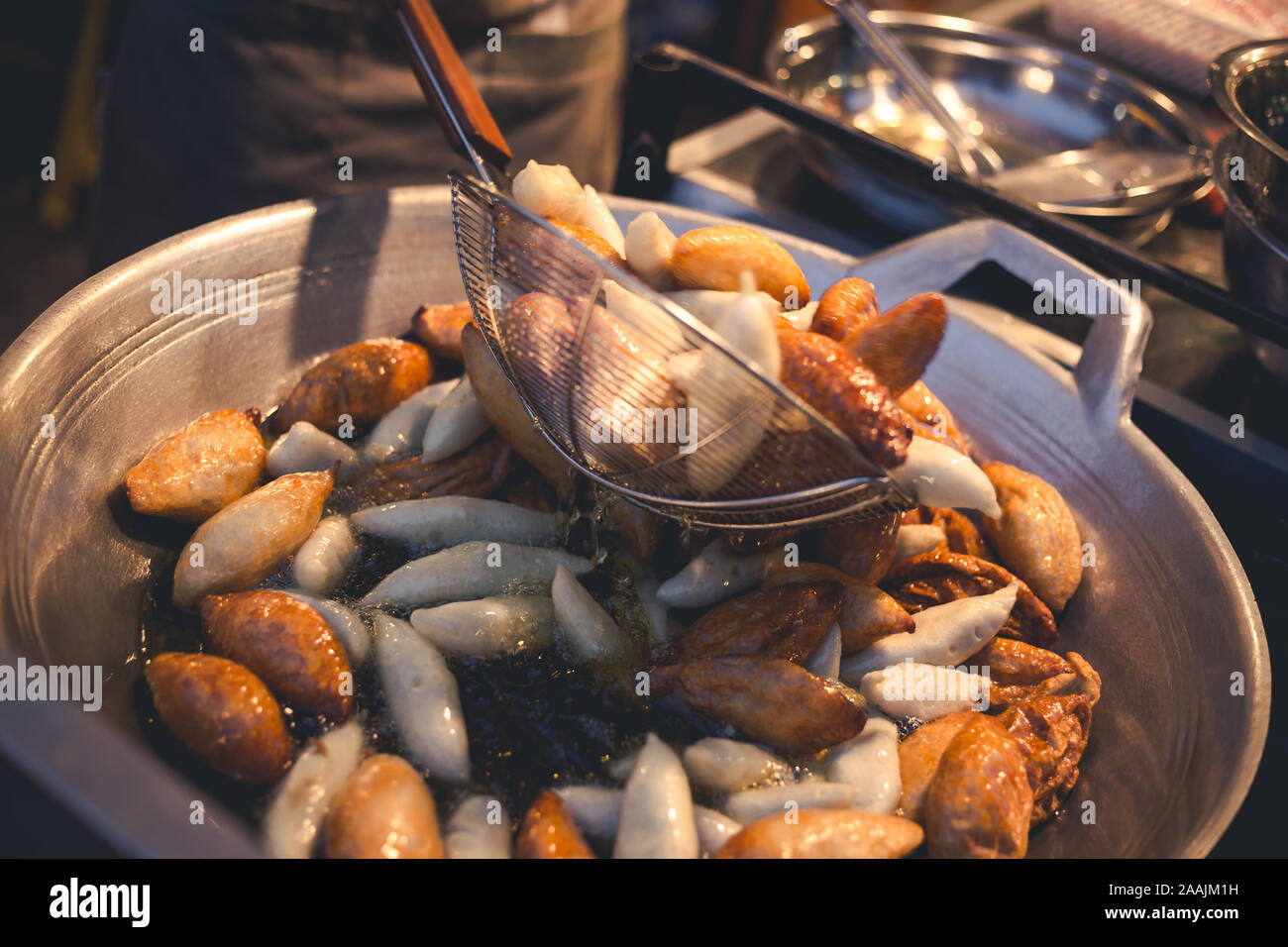 guy cooking make fry of meat ball from fish meat, also call fish ball ...