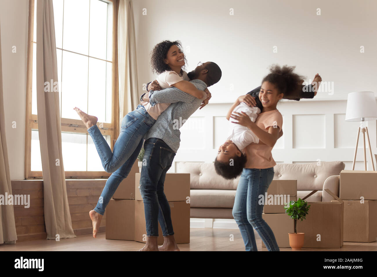 African family have fun in living room celebrating relocation day Stock ...