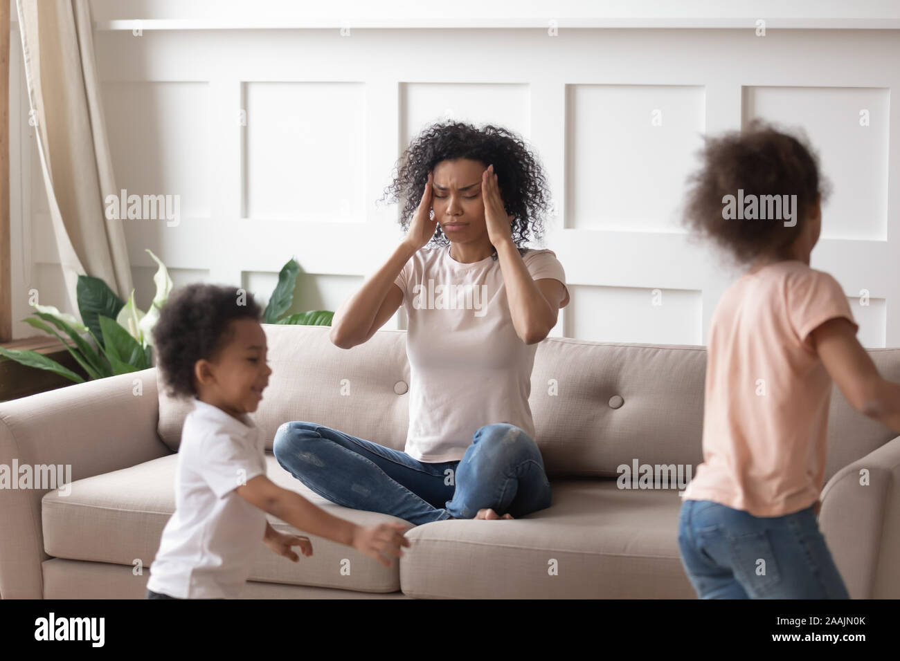 Mother suffers from headache because of noise of little children Stock ...