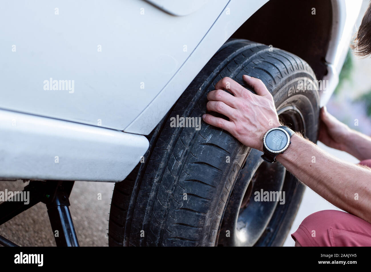 Replacing a tire punctured after hitting the curb Stock Photo - Alamy