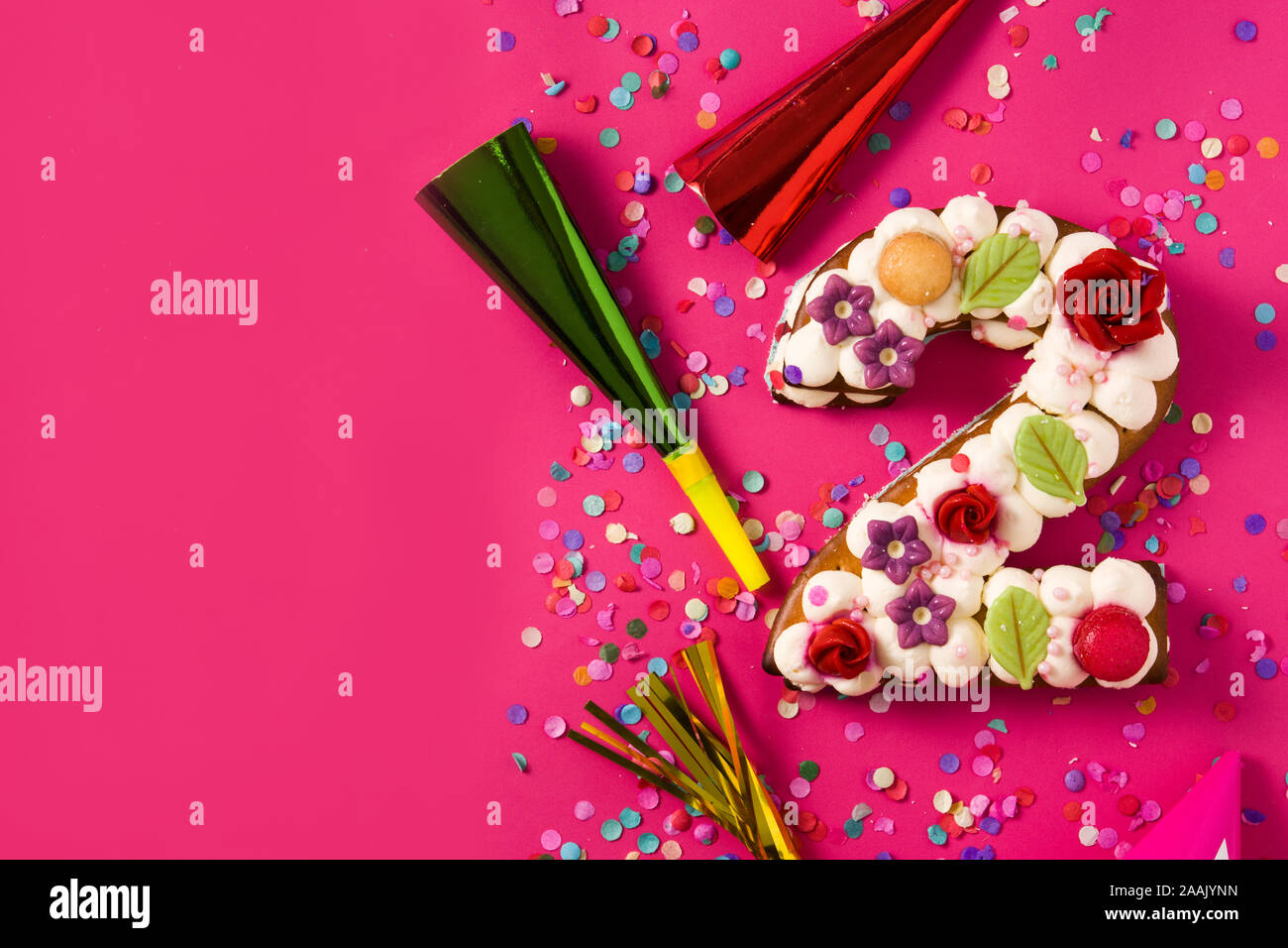 Number two cake decorated with flowers, macarons and confetti isolated ...