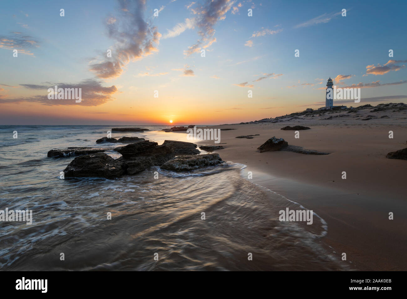 Cape Trafalgar lighthouse at sunset with waves breaking on beach, Los ...
